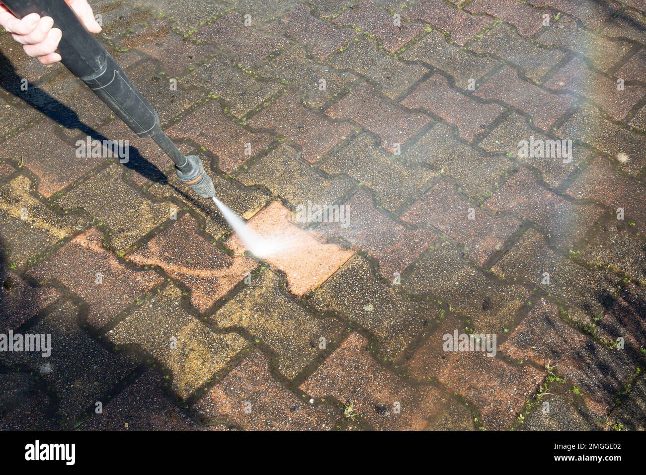 Cleaning concrete block floor driveway by high pressure water jet Stock ...