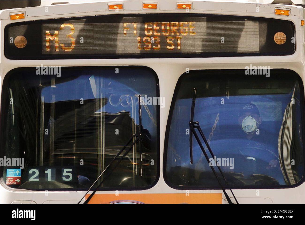 A busdriver wears a protective mask while operating the M3 bus along ...