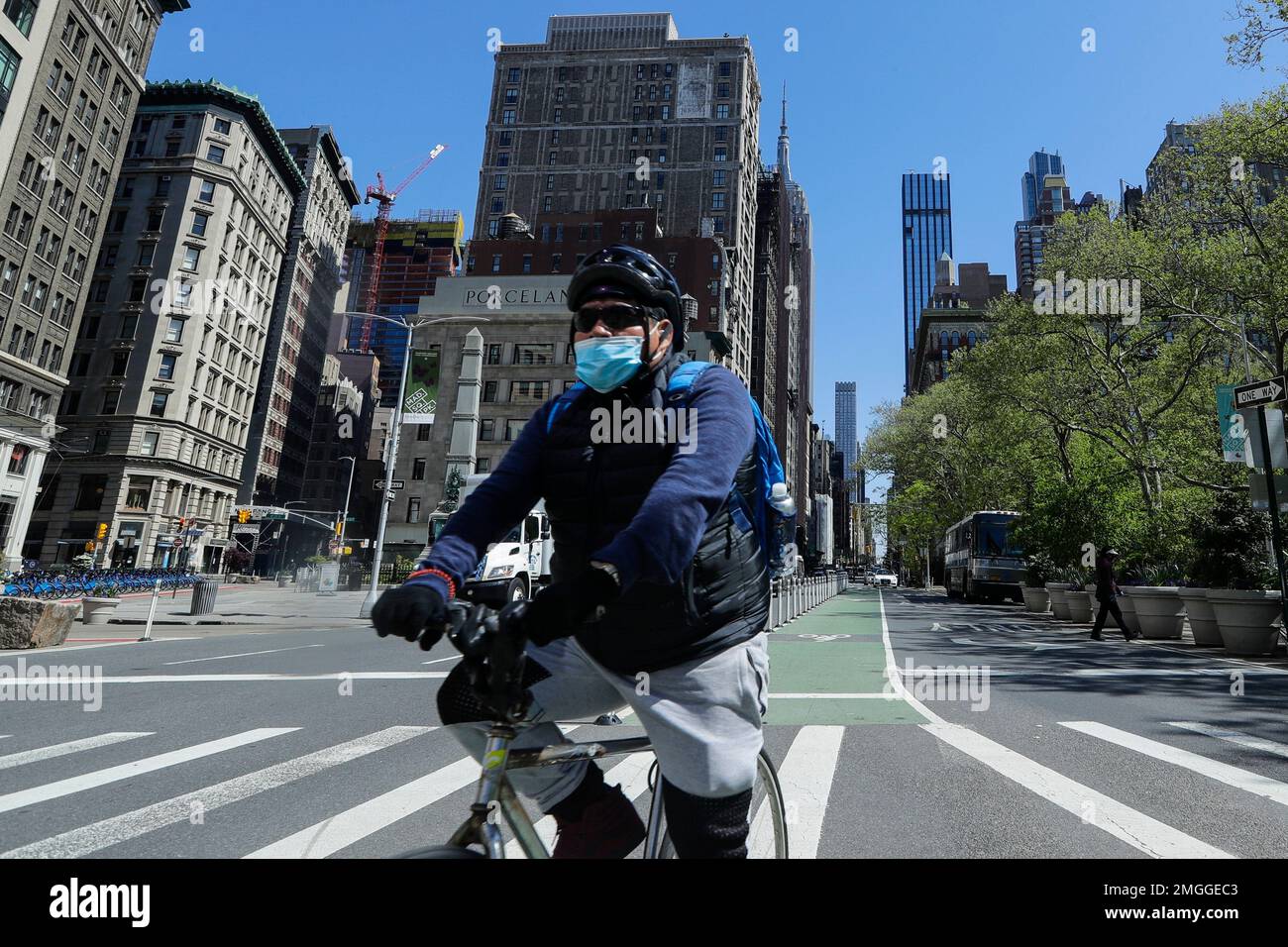A cyclist wears a protective mask as they pass Madison Square Park ...