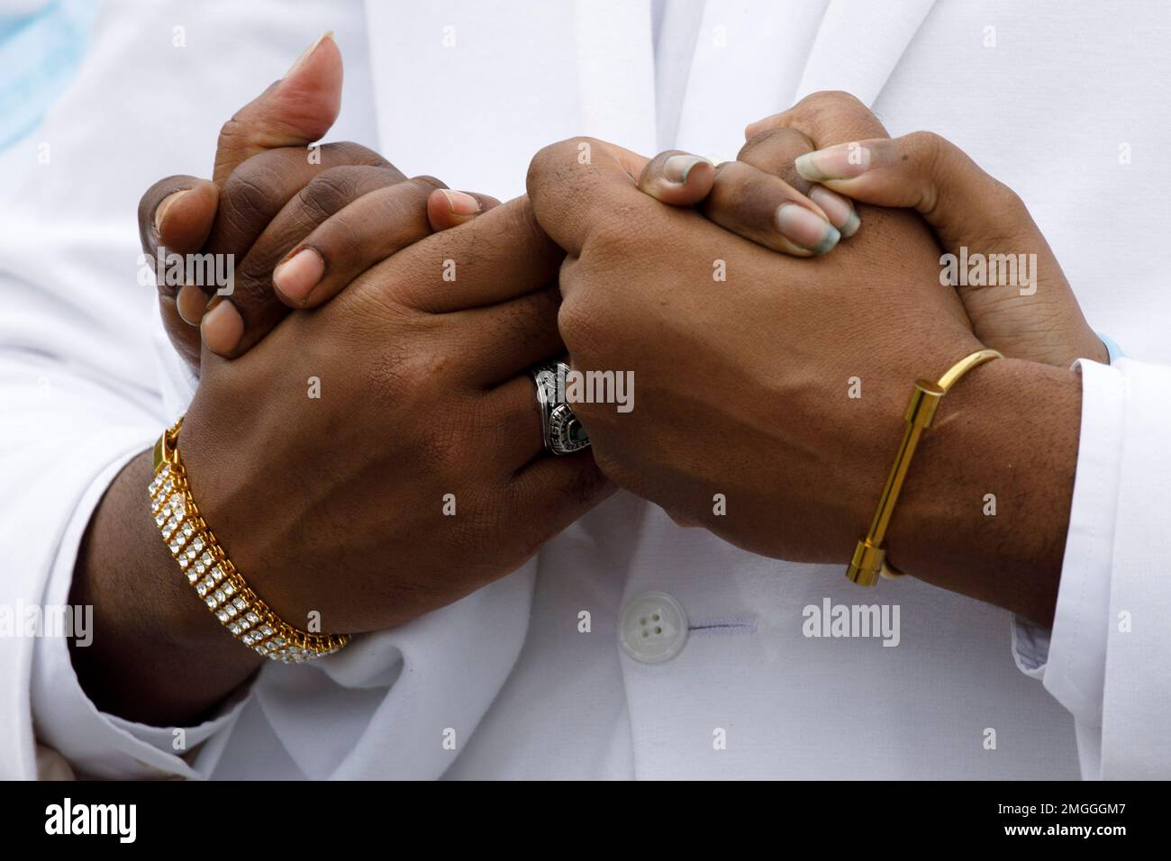 Iran "Bang" Paylor, of Washington, clasps hands with two of his sisters ...