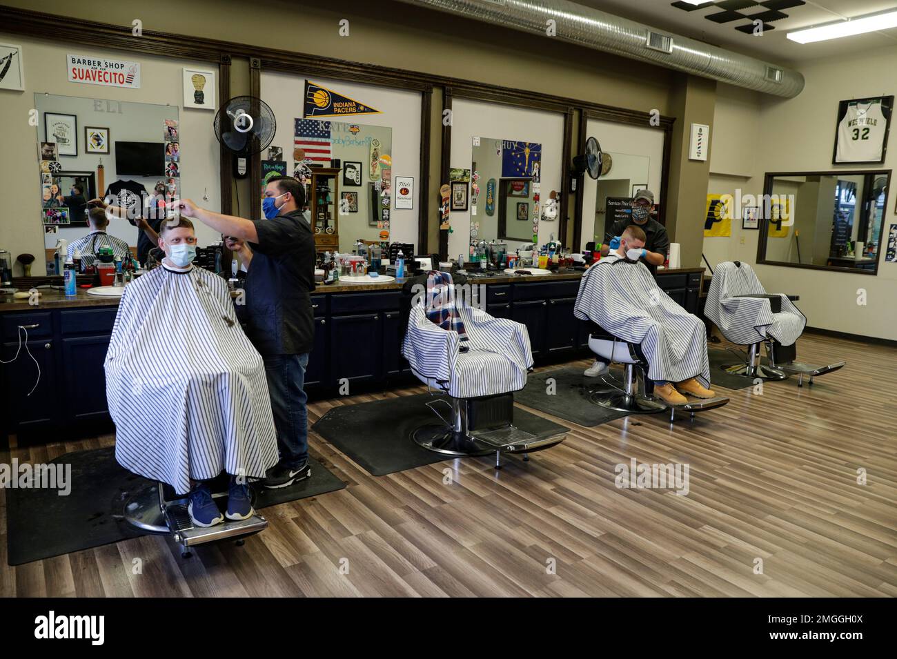 Eli Resendez, left, owner of the Barber Shop 32 in Westfield, Ind. and ...