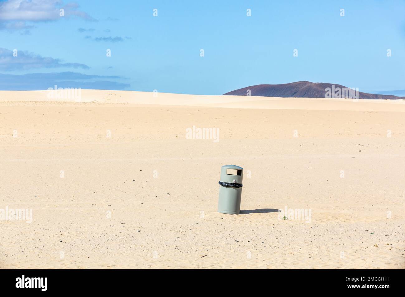 Trash isolated in the dune field of Corralejo. Dark mountains on the ...