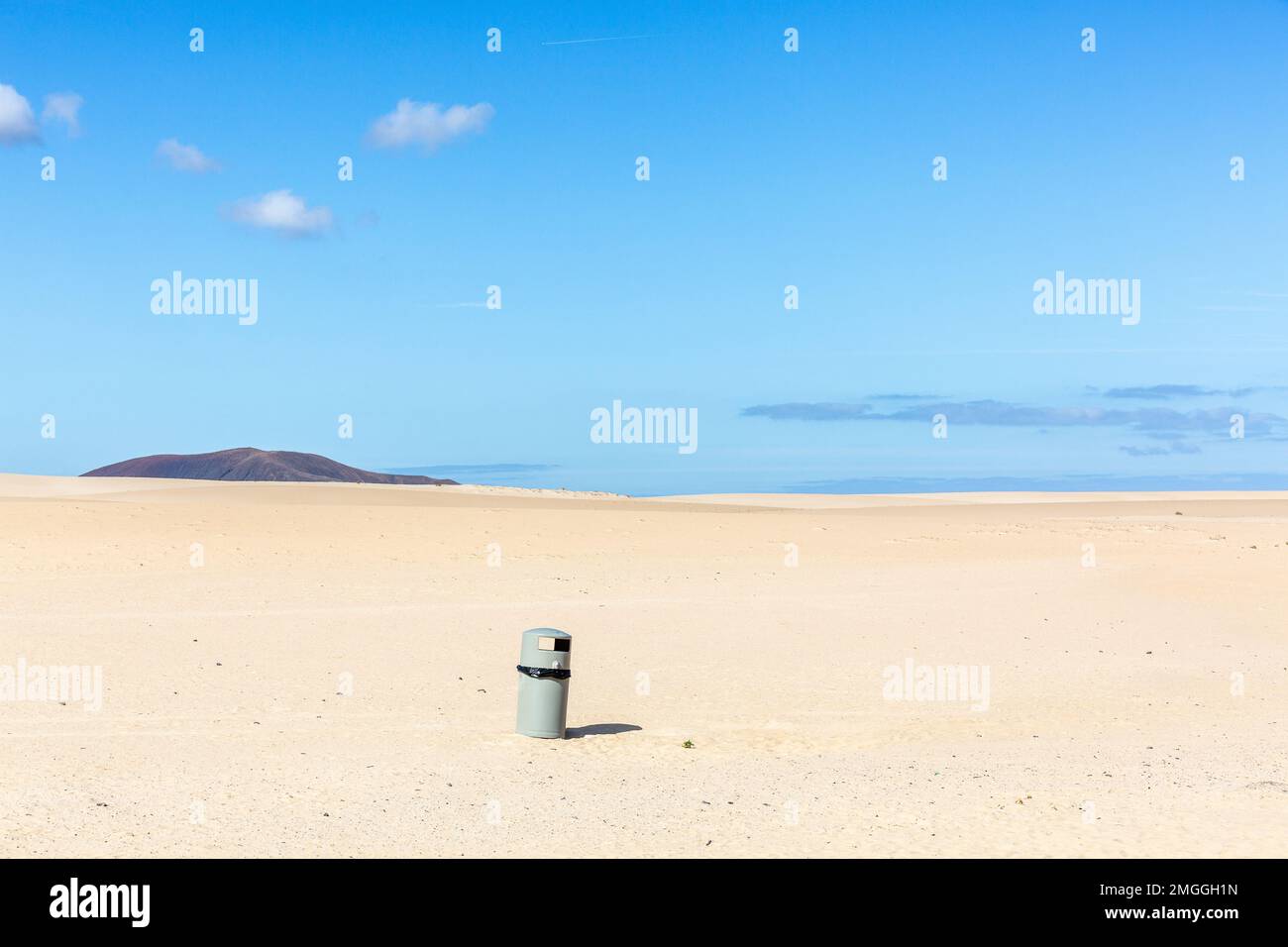 Trash isolated in the dune field of Corralejo. Dark mountains on the ...