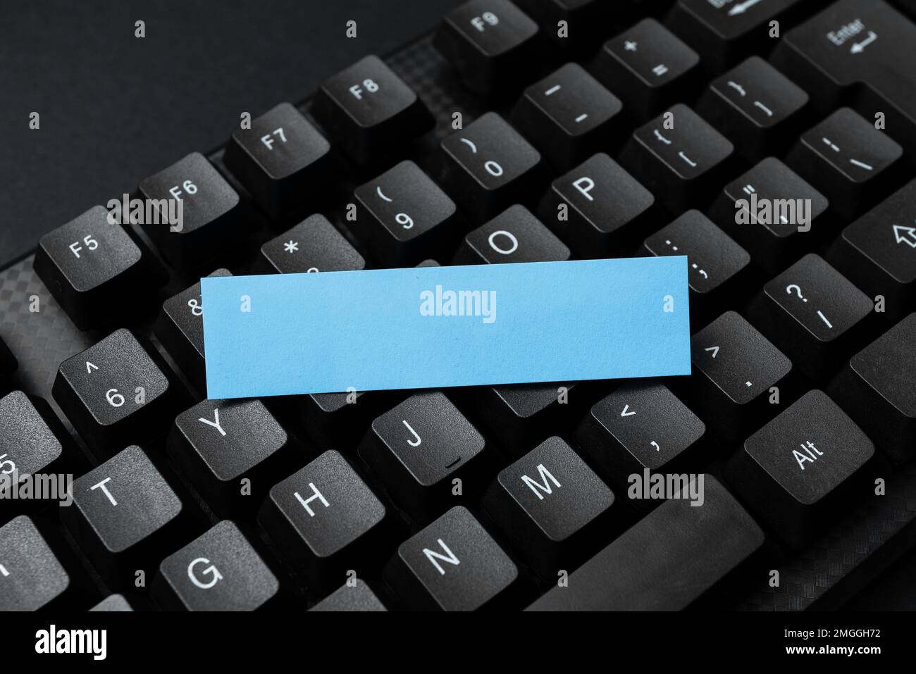 Sticker lying on black keyboard. Important message written over paper ...