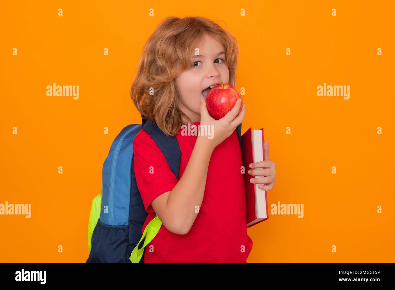 School kids eat apple. Child from elementary school with book and apple ...