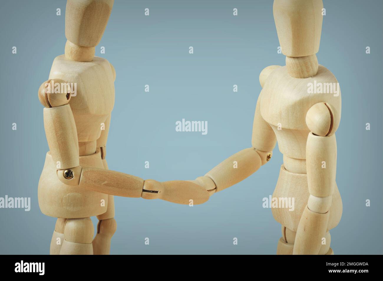 Two wooden mannequins shaking hands - Concept of peace Stock Photo - Alamy