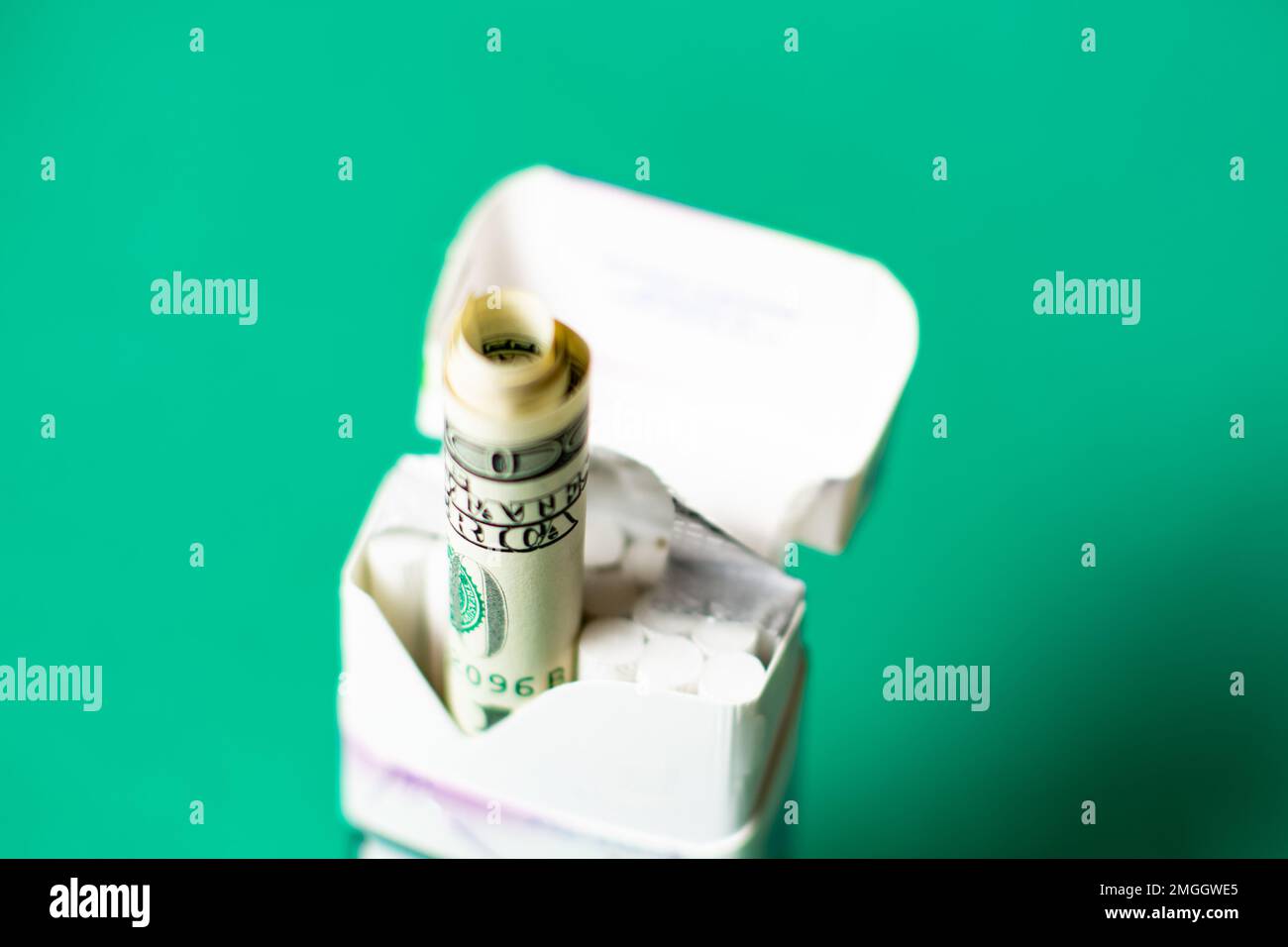 Smoking and money. Rolled up dollar bill in a cigarette pack. Green ...