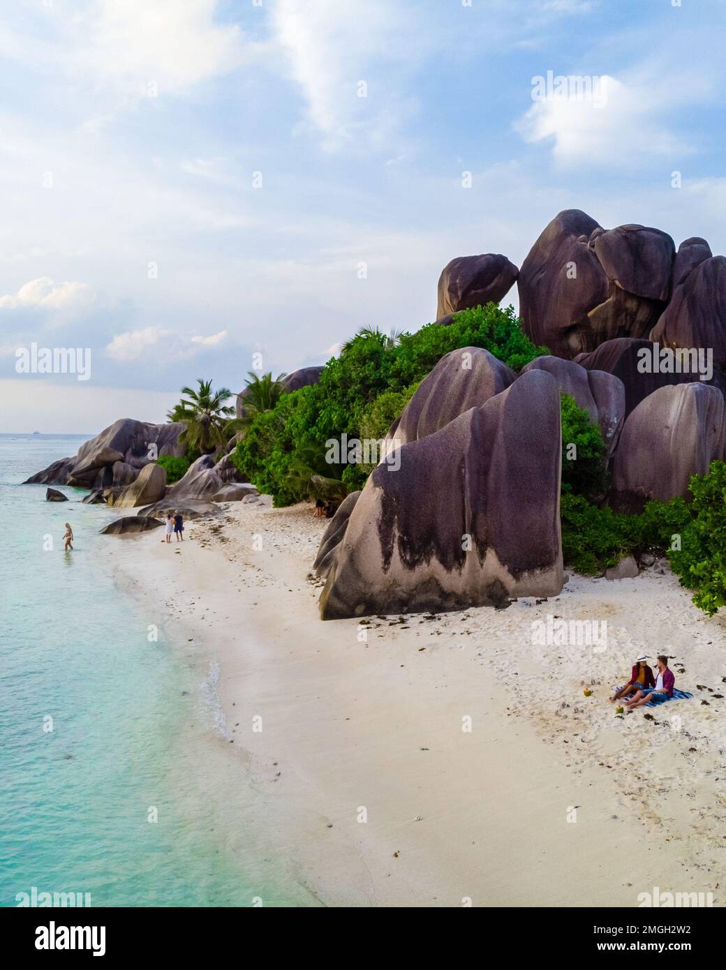 couple men and woman relaxing on a tropical beach, Drone view from ...