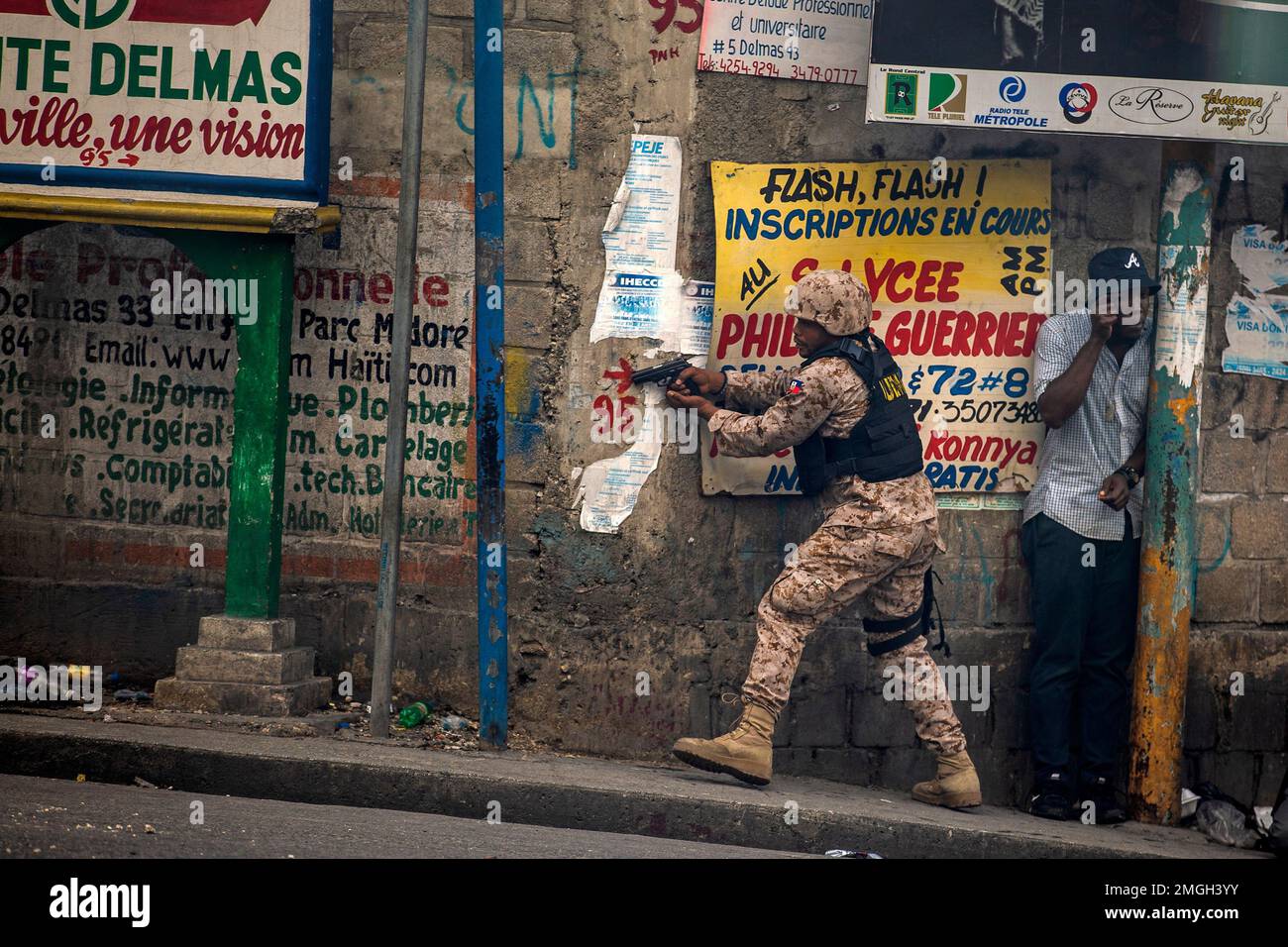 A police officer points his gun at residents of Delmas 95 district ...
