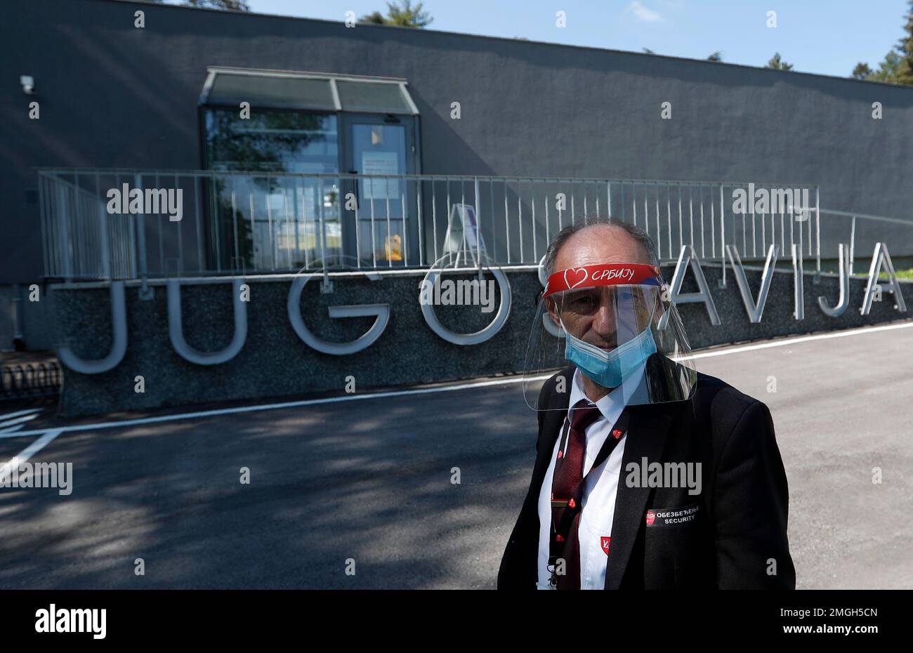 A security worker wearing a plastic shield reading: ''I love Serbia ...