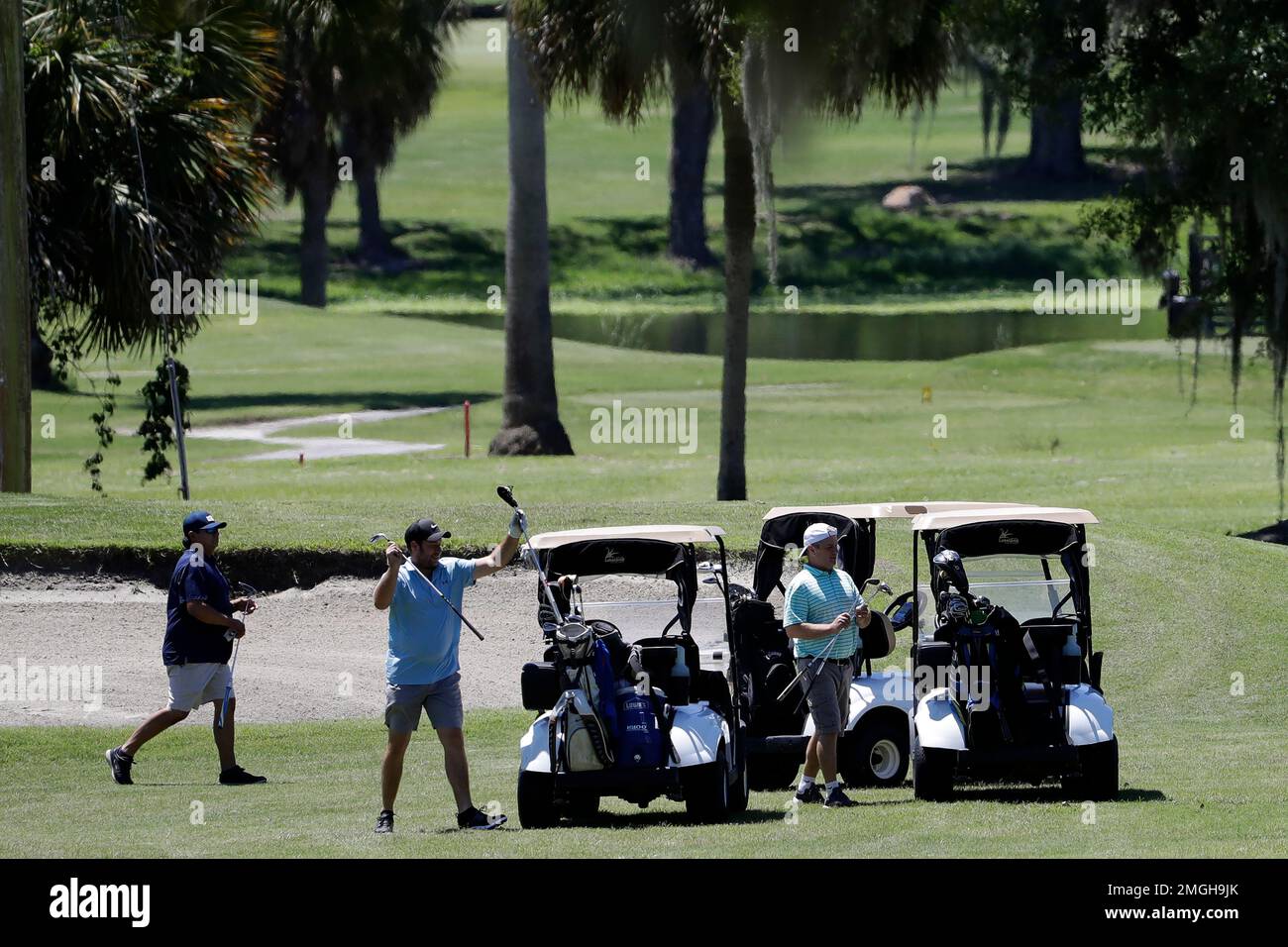 Golfers head back to their carts after playing the first hole at the ...