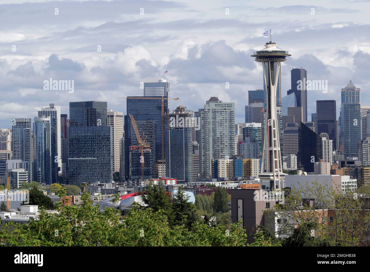 The Space Needle and the Seattle skyline are shown against a cloudy sky ...