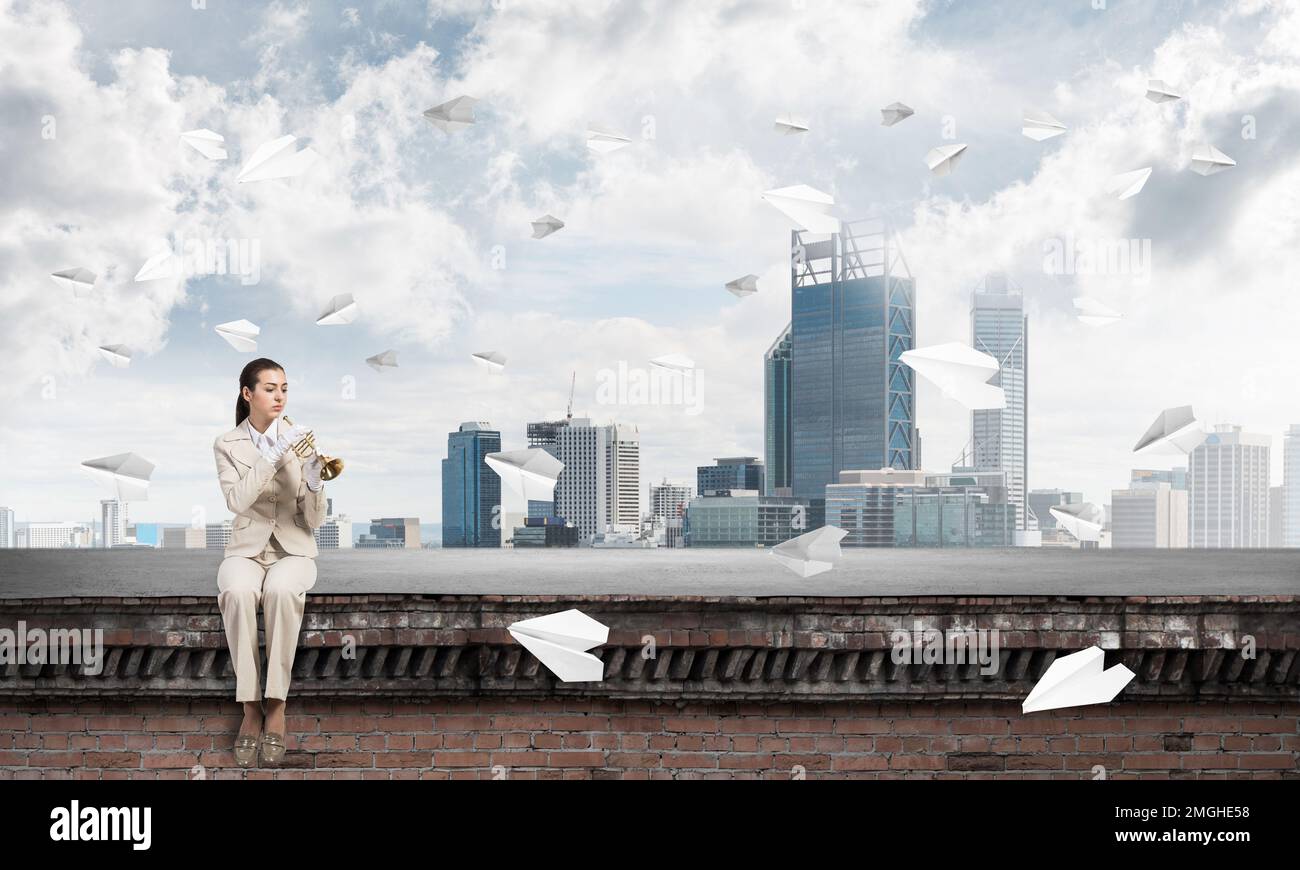 Elegant young woman playing trumpet Stock Photo - Alamy
