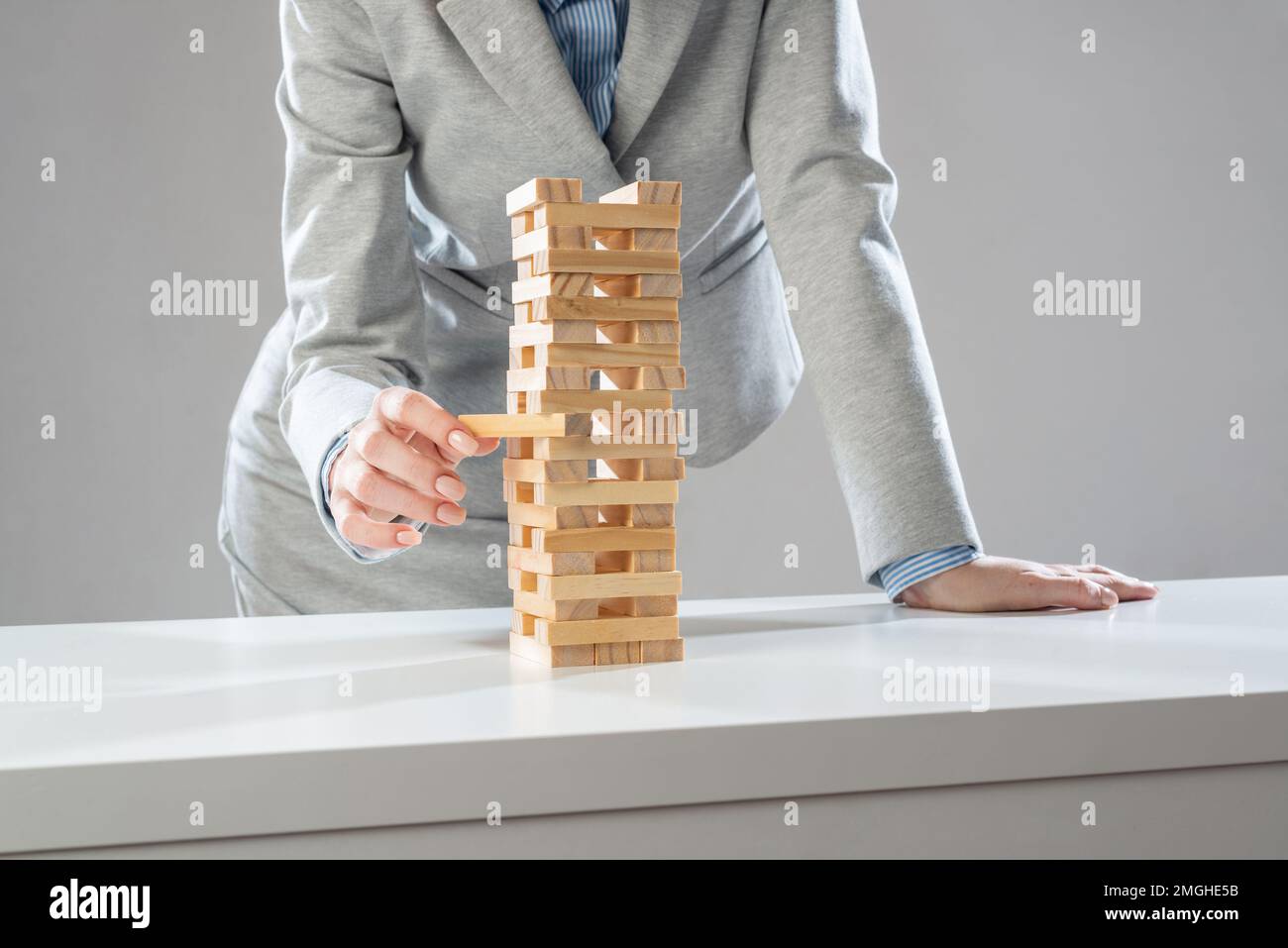 Business woman building tower from wooden blocks Stock Photo - Alamy