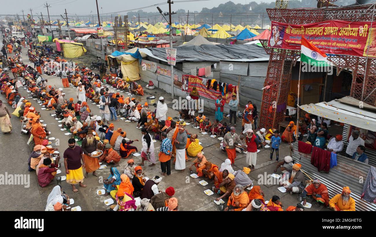 Hindu devotees participate in a community feast at the Sangam, the ...