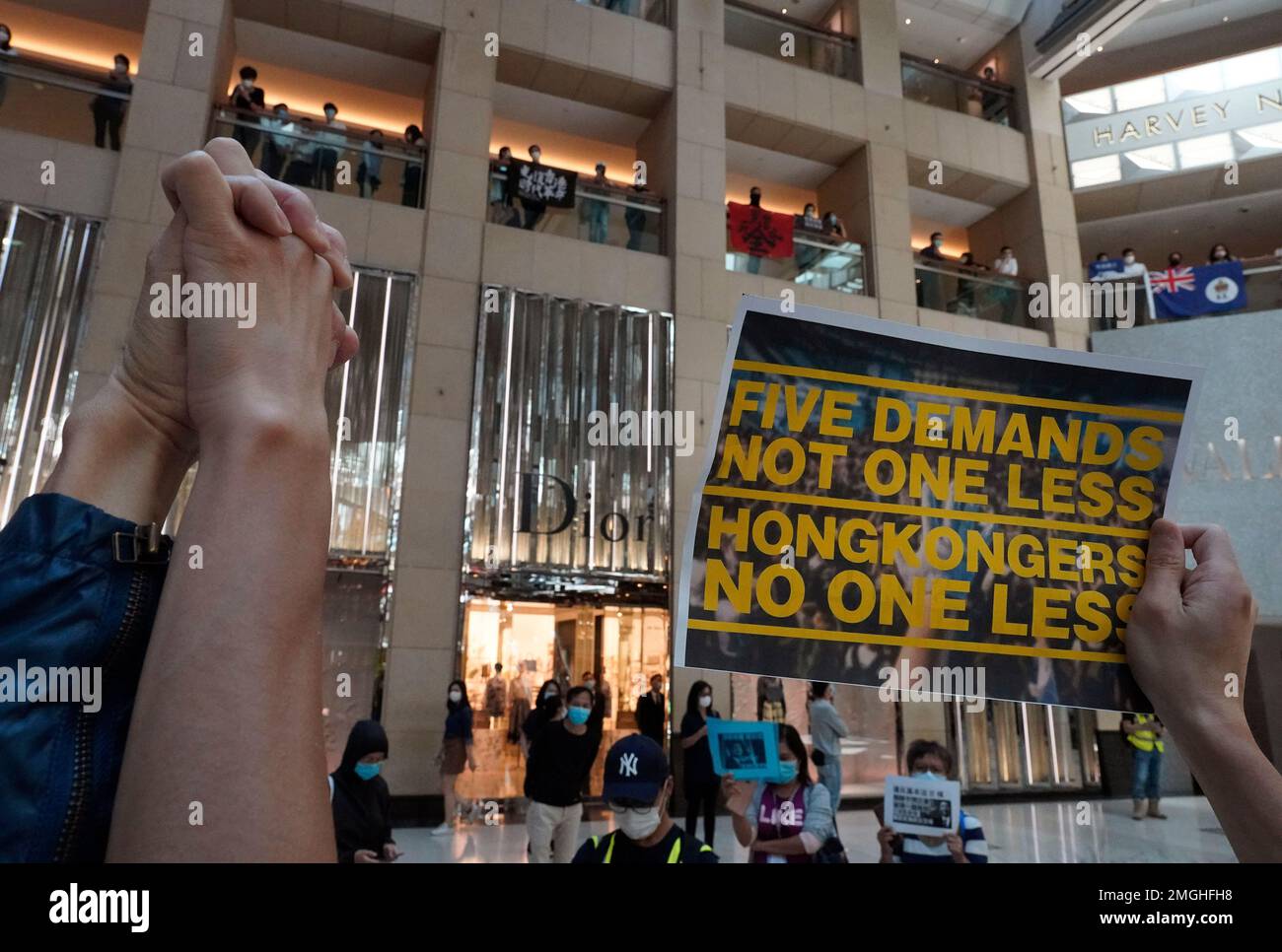 A protestor raises a placard during a protest at a shopping mall in ...