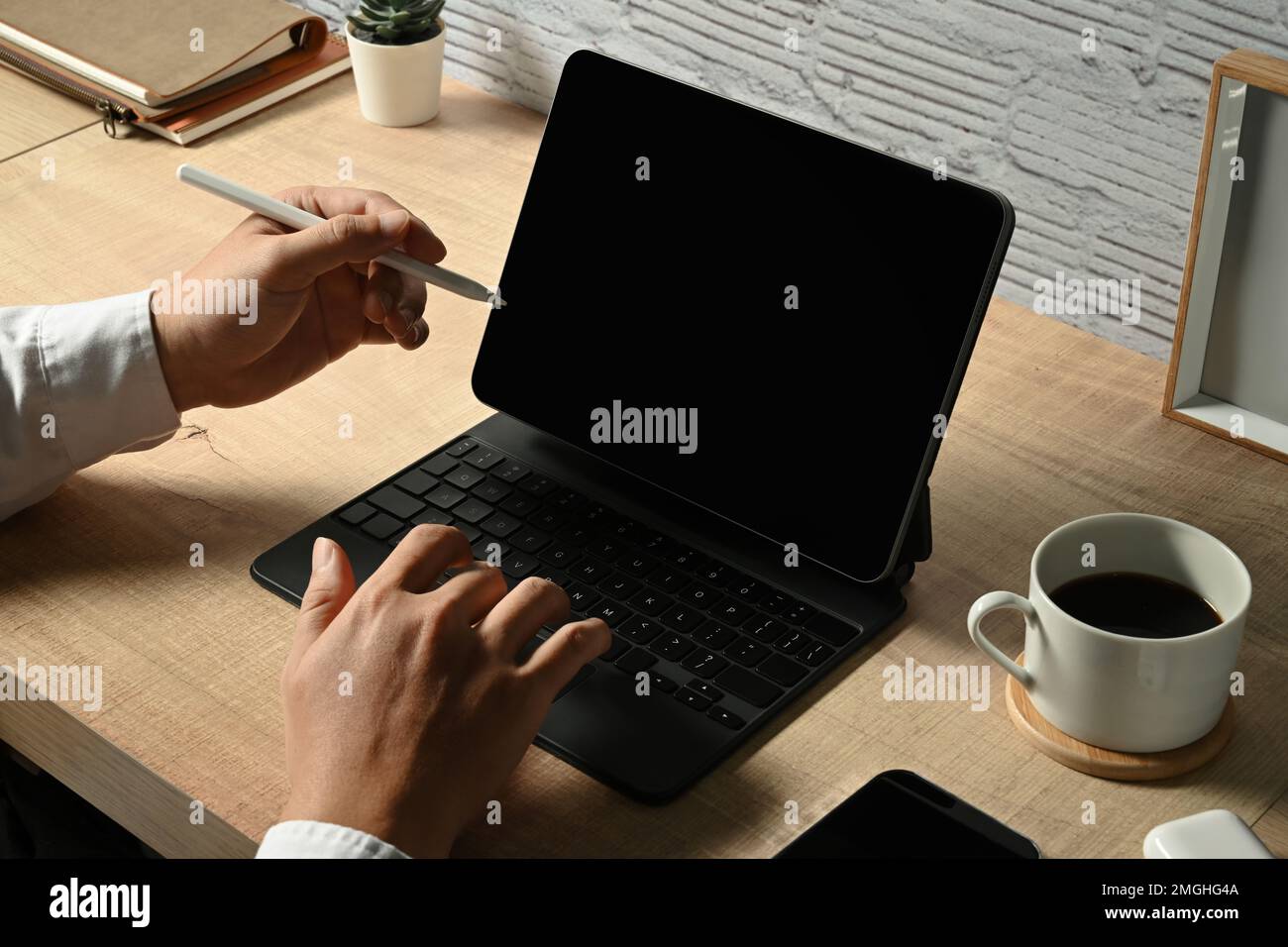 Cropped image of businessman using stylus pen writing on tablet screen ...