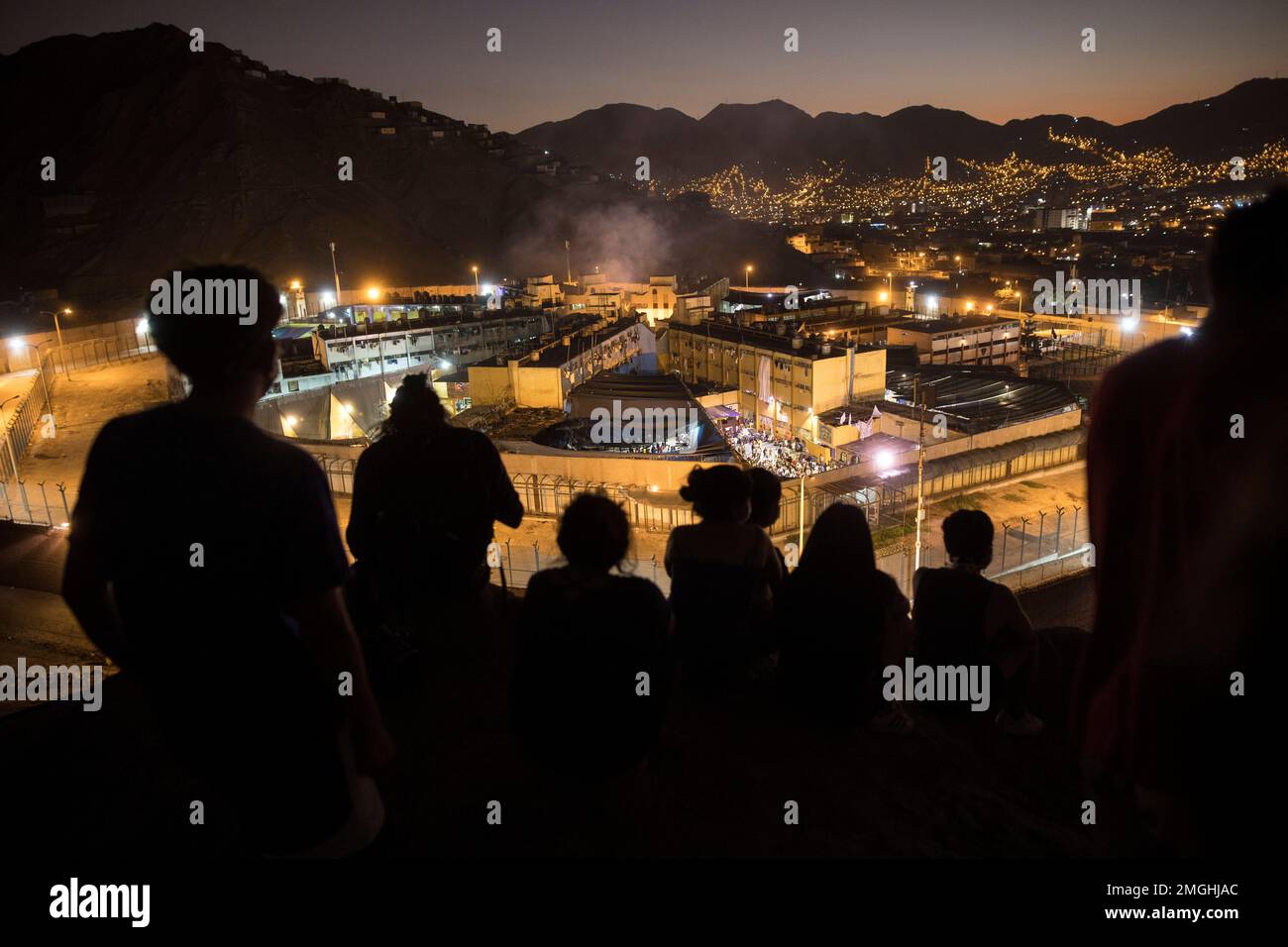 Relatives look at the Castro Castro prison during a prison riot in Lima ...