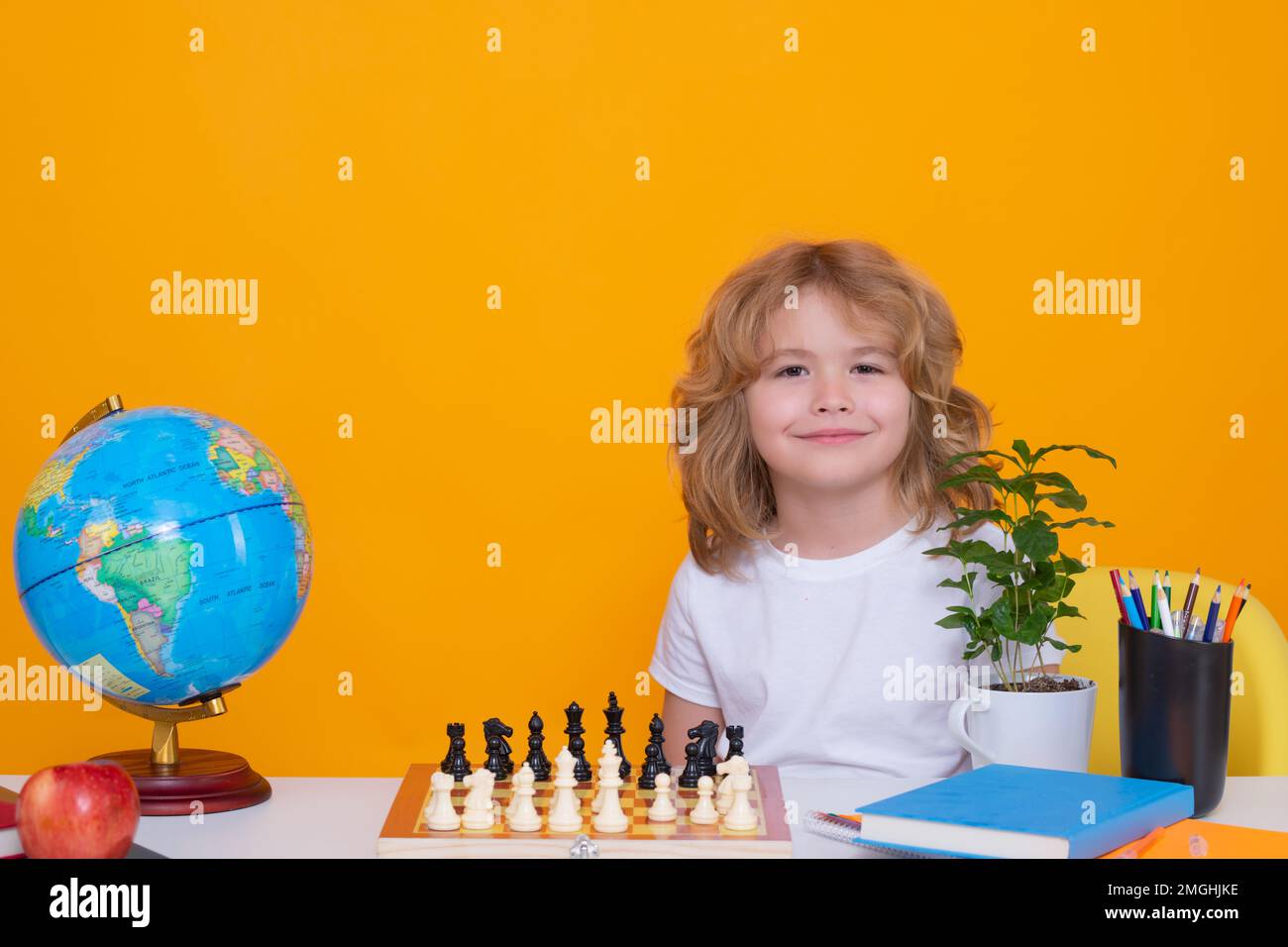 Kid play chess on isolated studio background. Kid thinking about chess ...