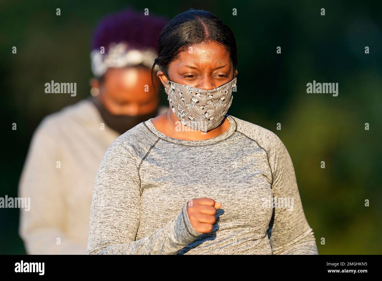 Kedria Grigsby walks along a park trail while wearing a face mask to ...