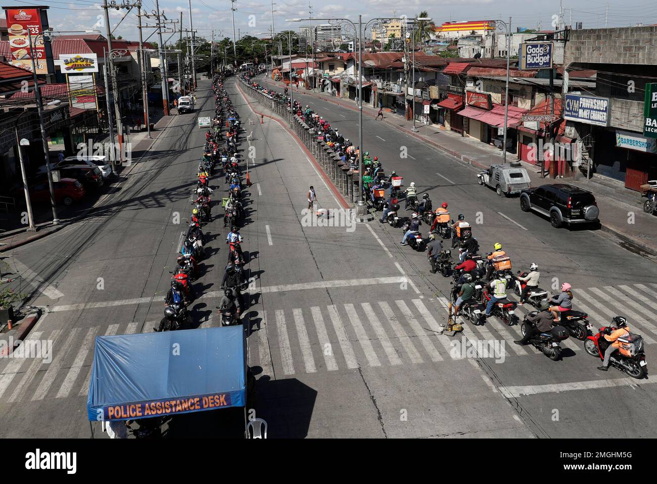 A man passes by rows of motorcycle riders at a checkpoint during an ...