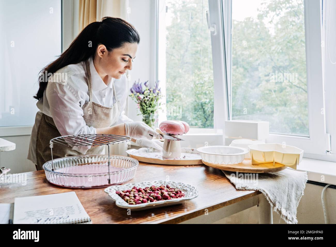 Female baker make Perfect custom pink heart shape cake in kitchen ...