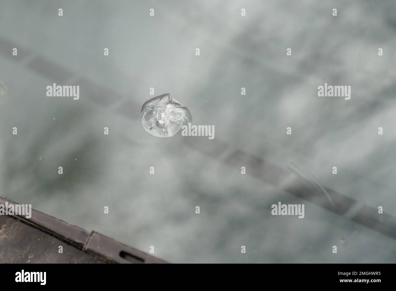 impact and damage to the windshield glass of a car Stock Photo - Alamy