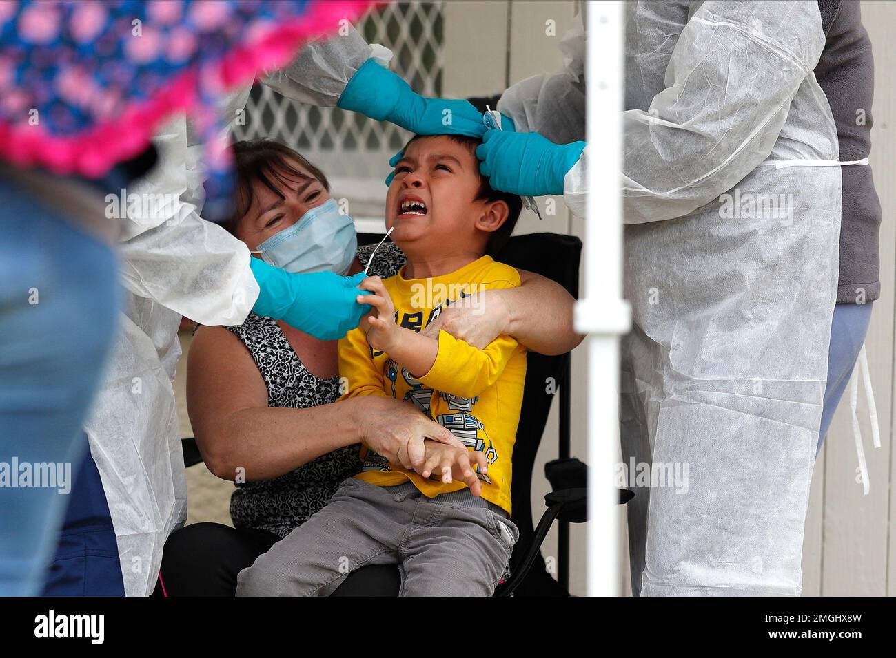 Angel Landaverde, 4, is restrained by his aunt Vilma Landaverde, center ...
