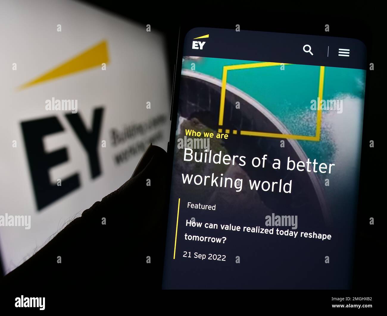 Person holding cellphone with webpage of company Ernst Young Global ...