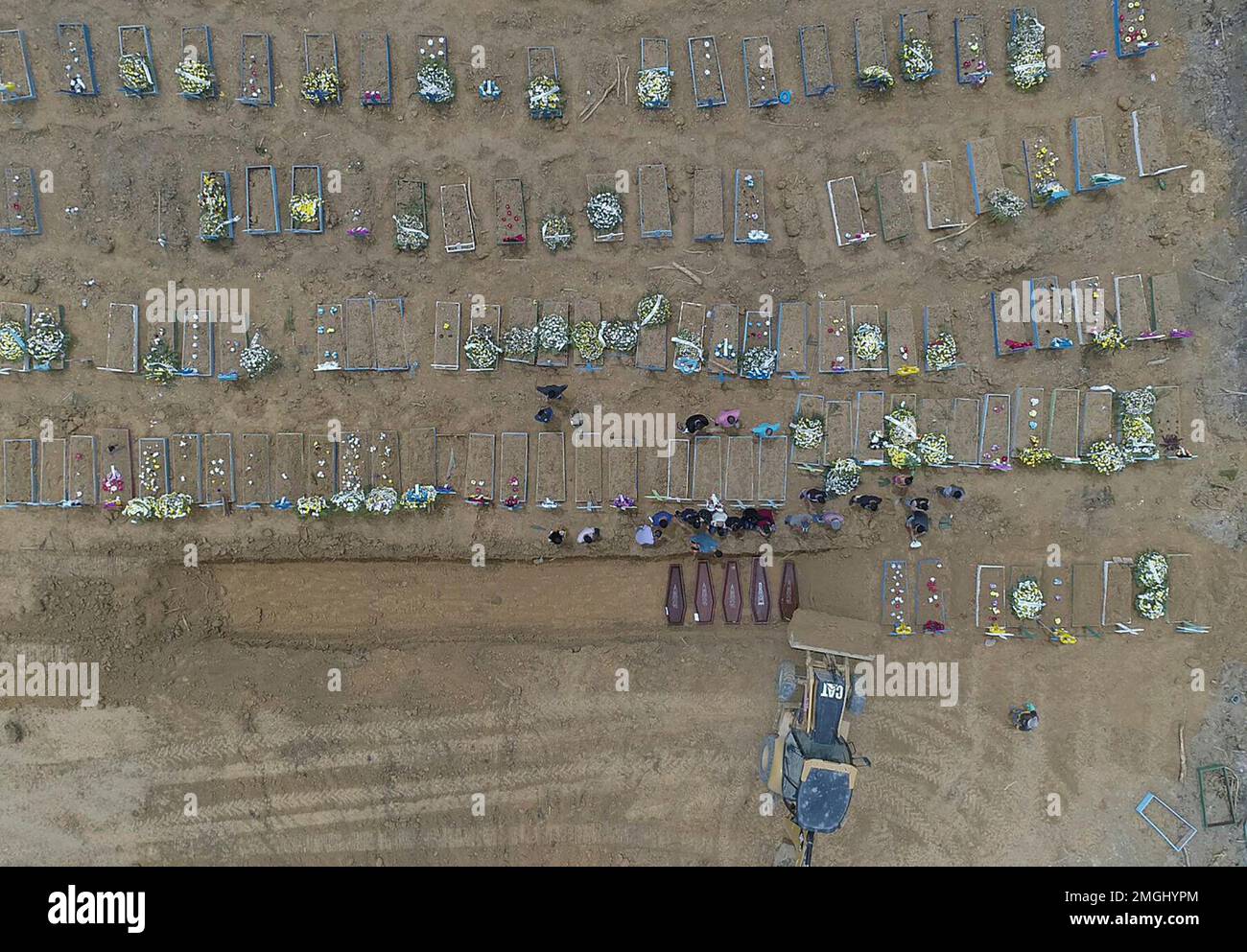 A backhoe buries coffins in a common pit at the Nossa Senhora Aparecida ...