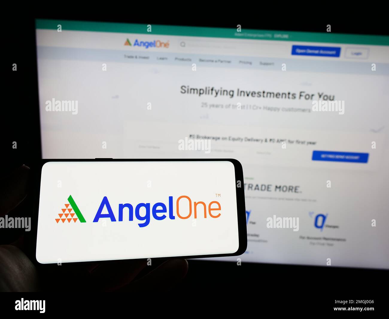 Person holding mobile phone with logo of Indian brokerage company Angel ...