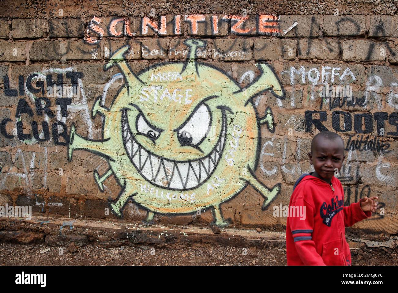 A child walks past an informational mural depicting the new coronavirus ...