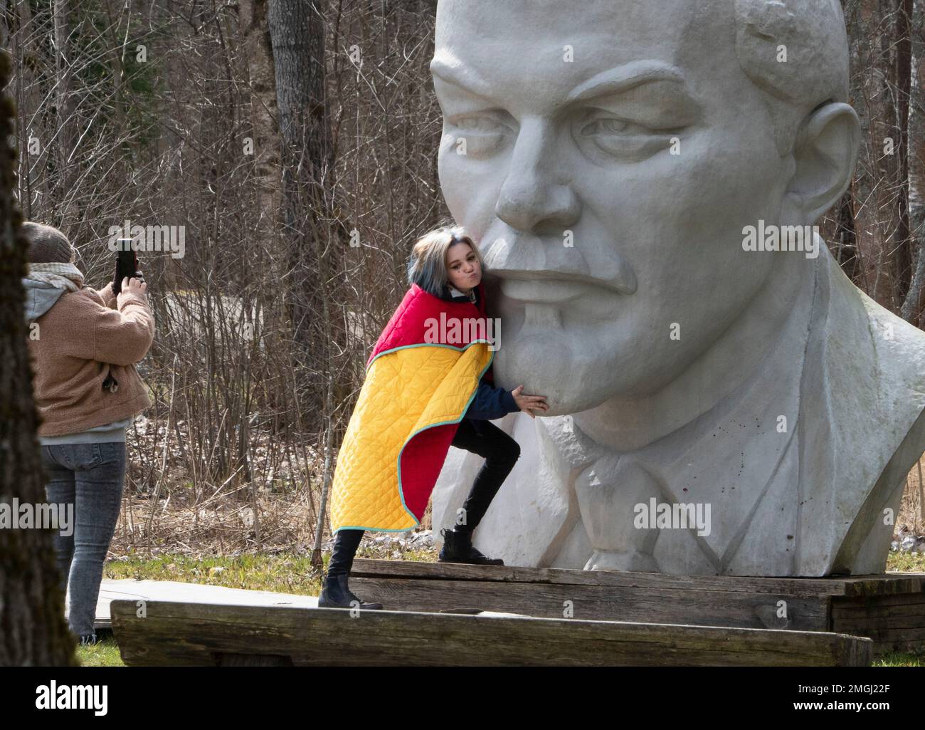 A woman poses for a photo at a statue of Soviet Union founder Vladimir ...