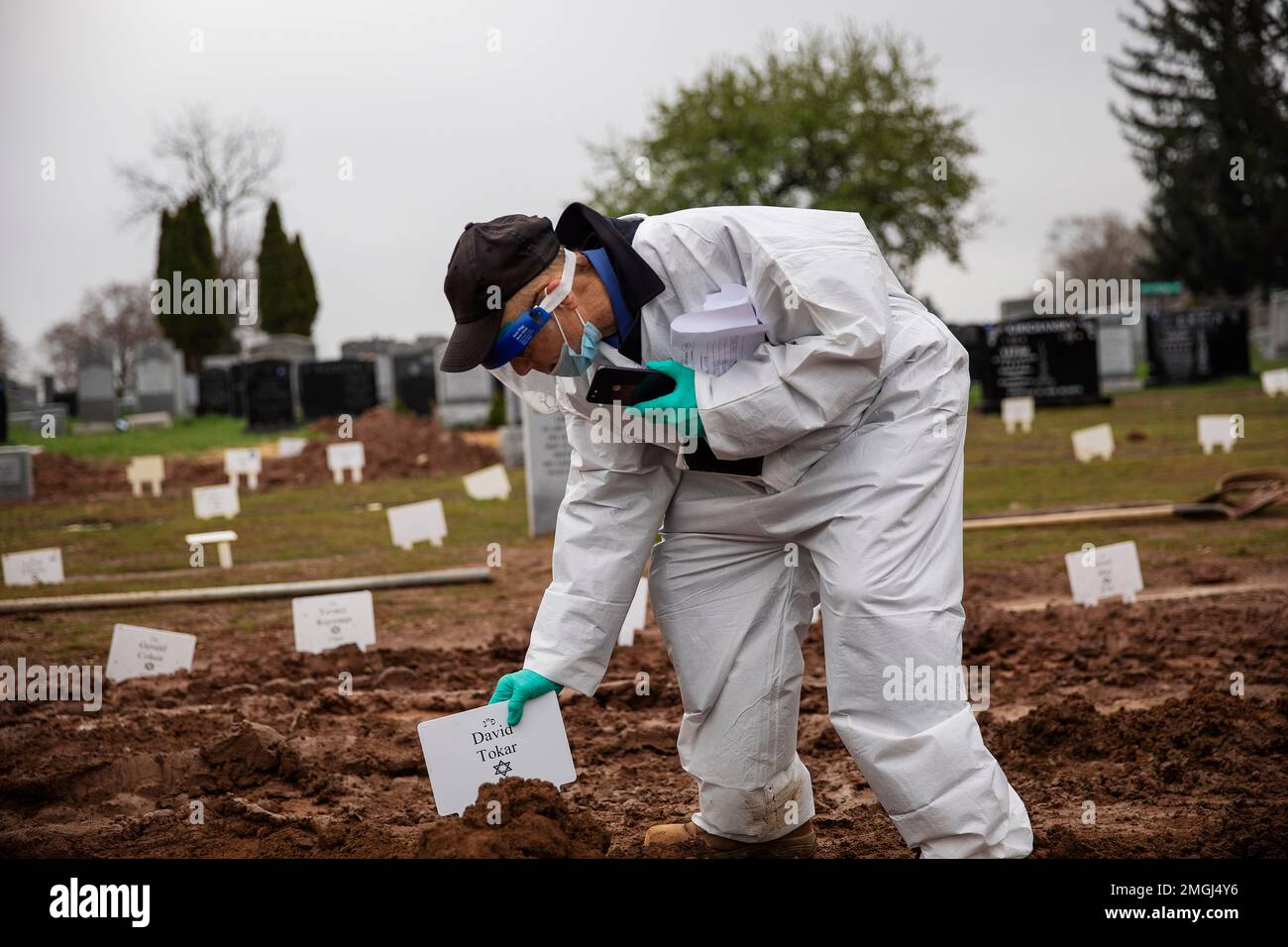 Rabbi Shmuel Plafker places a temporary marker at the grave of David ...