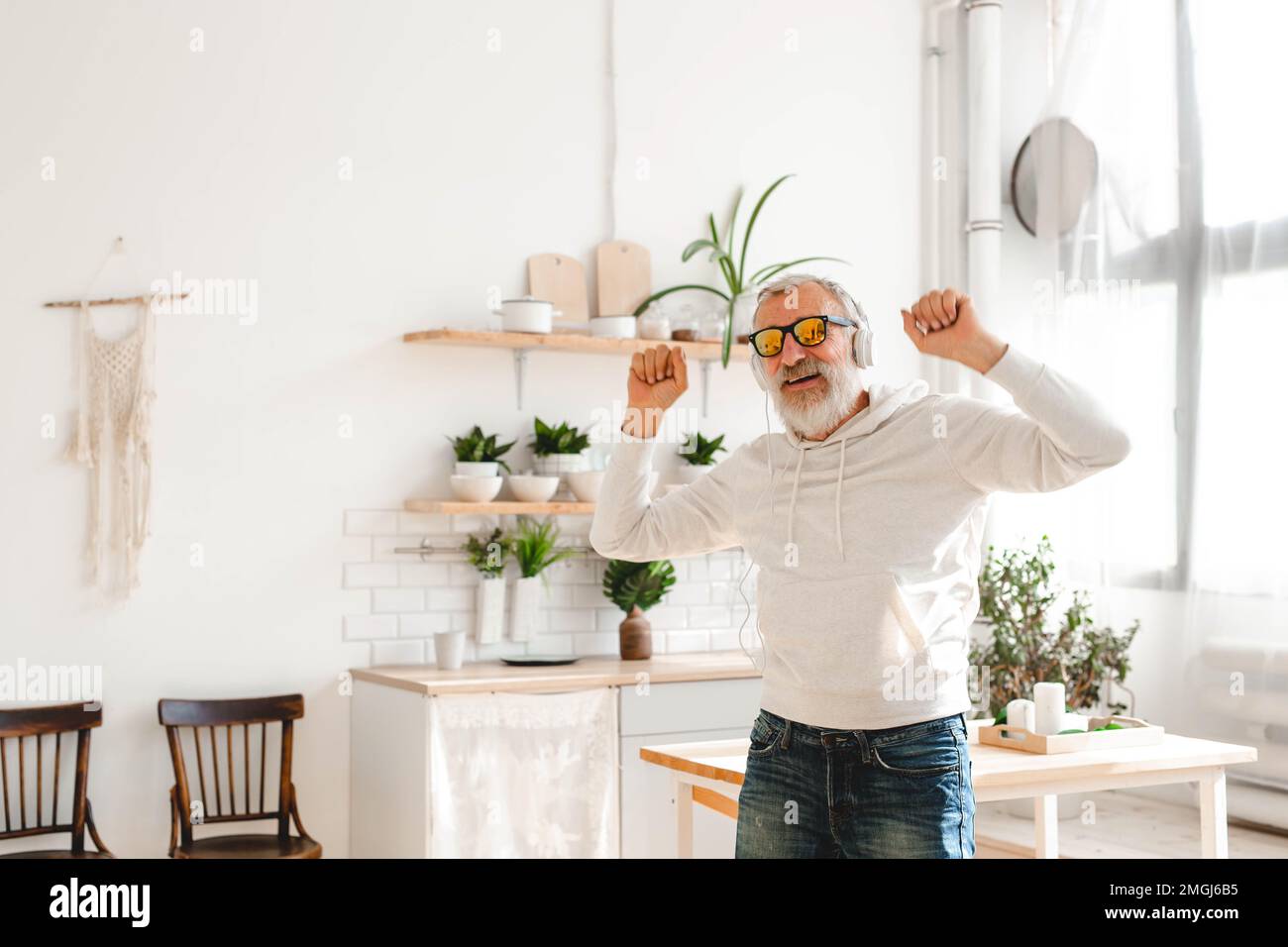 Happy senior man dancing while listening to music with headphones ...