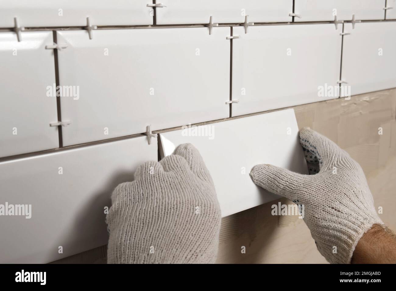 Male Worker Master Laying Ceramic Tiles on the Wall of Kitchen ...