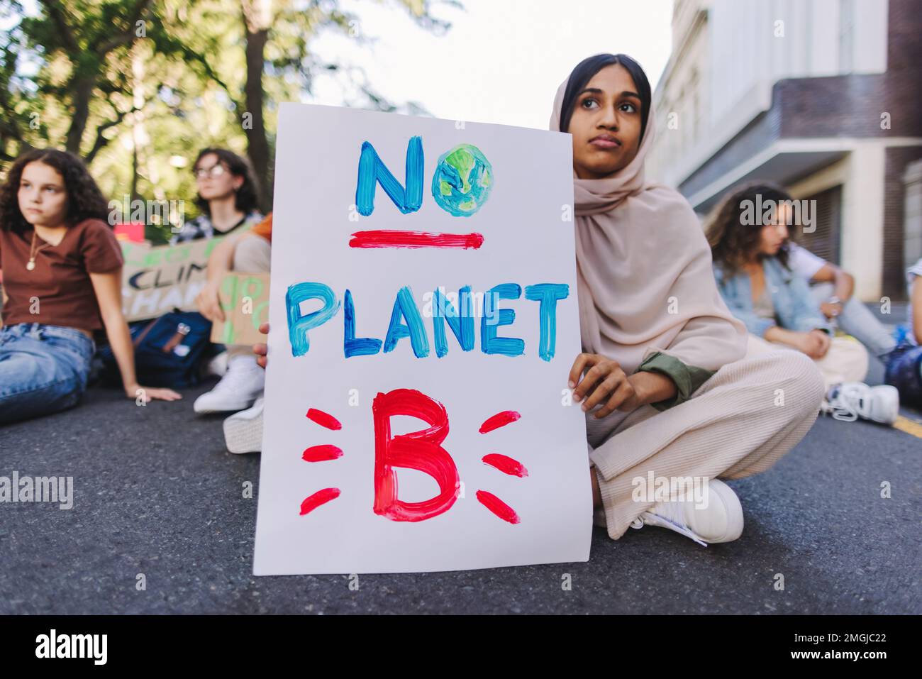 Young Muslim girl holding a "No planet B" poster at a climate change ...