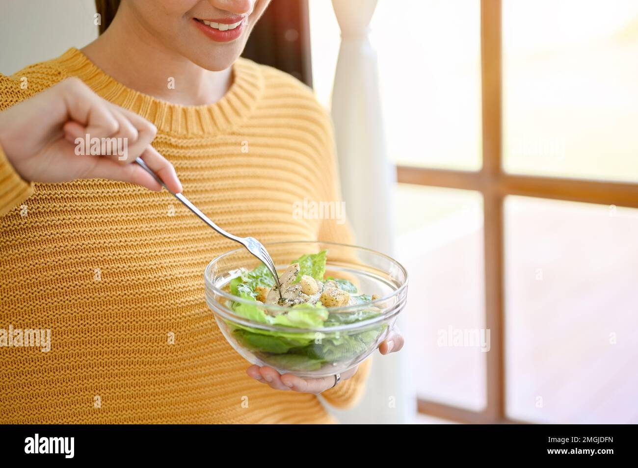 cropped and close-up image, Beautiful woman holding a salad bowl ...