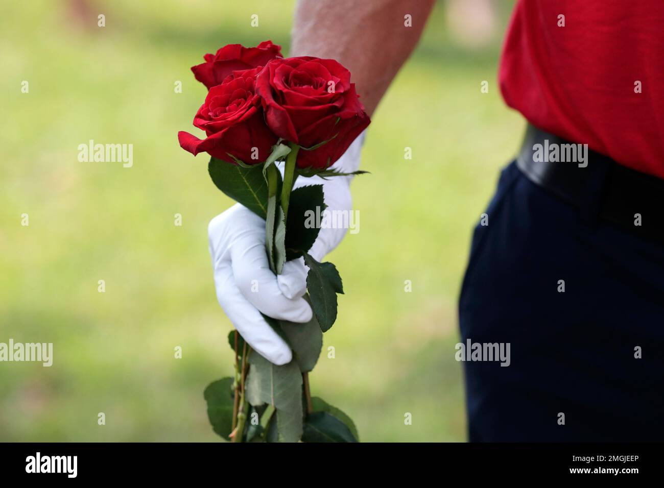 A City of Hialeah Fire Rescue worker holds red roses during a parade ...