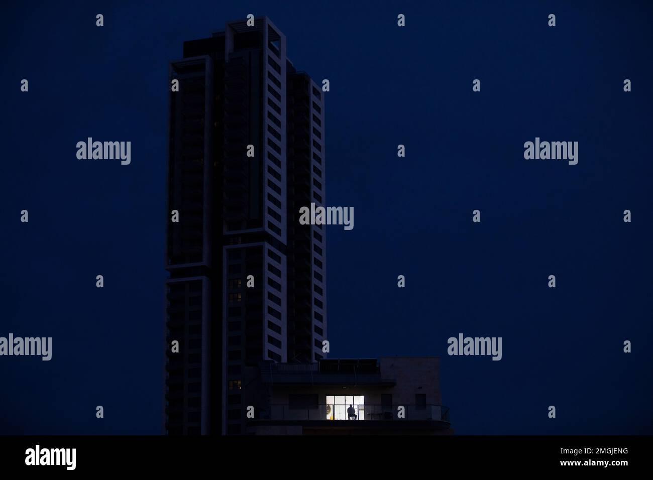 A man sits on his balcony during lockdown following government measures ...