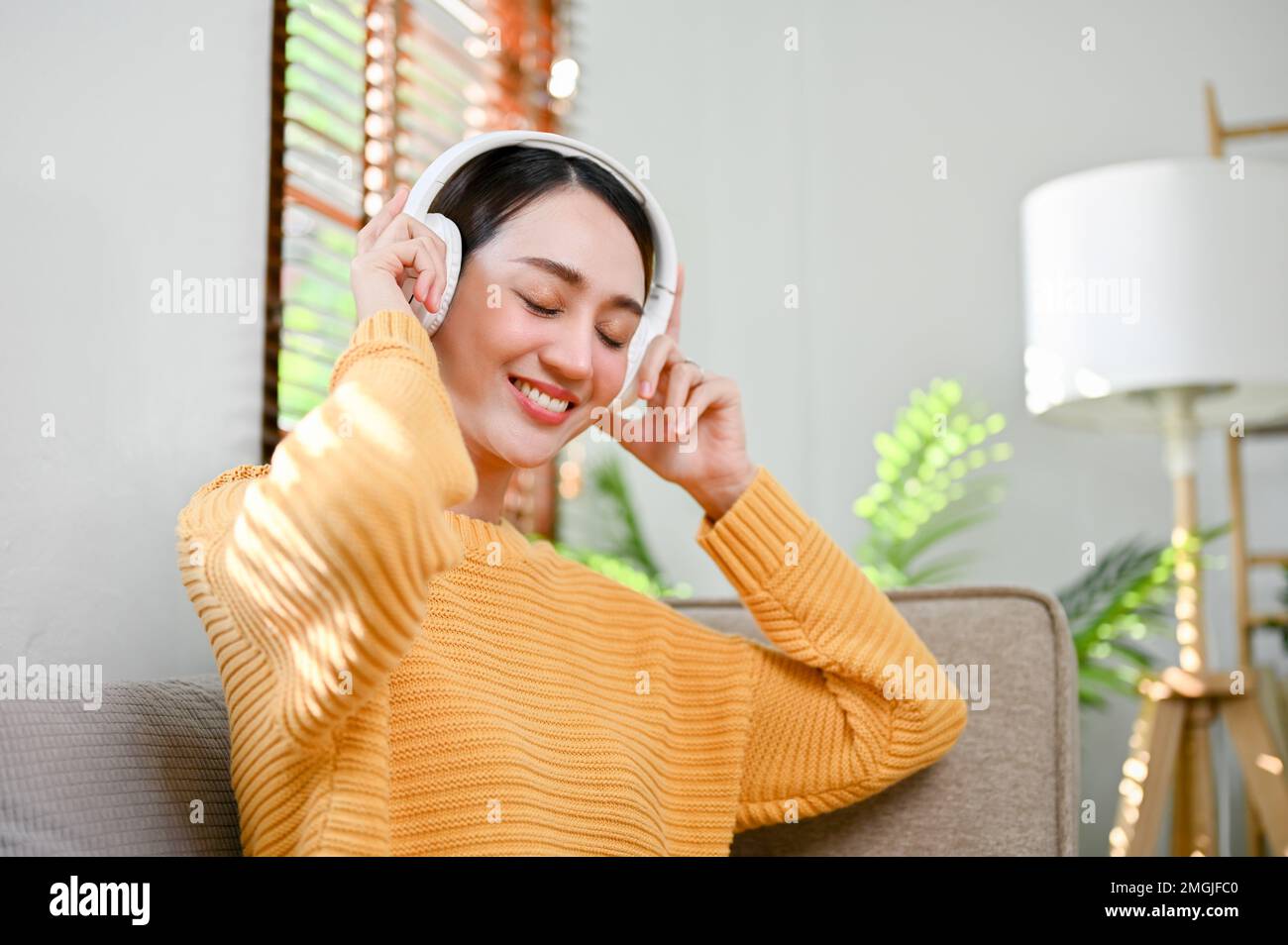 Charming and attractive millennial Asian woman in casual clothes eyes ...