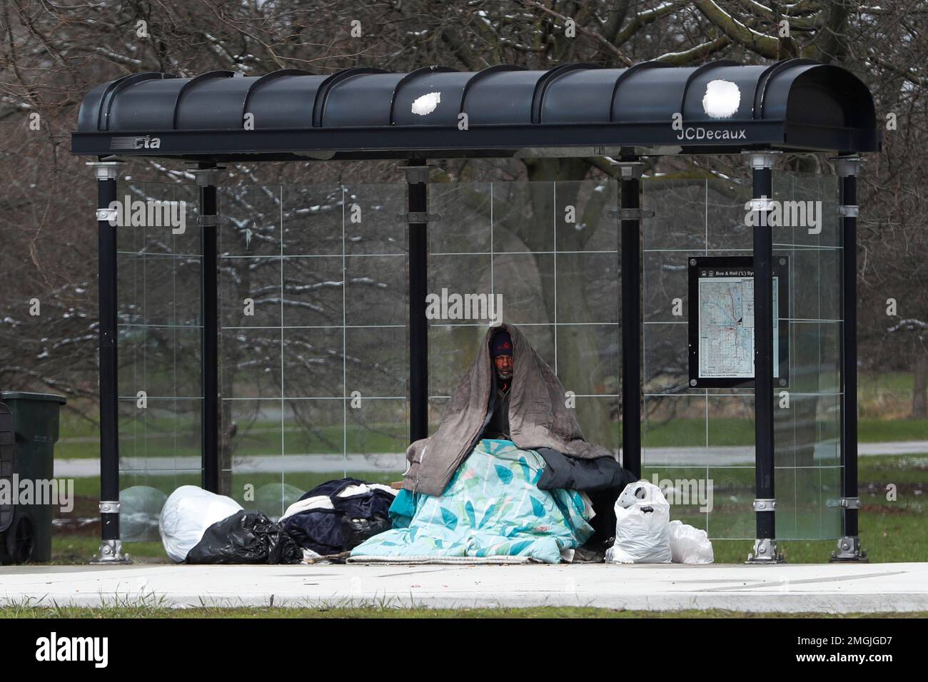 A homeless man occupies a Chicago Transit Authority bus shelter during ...