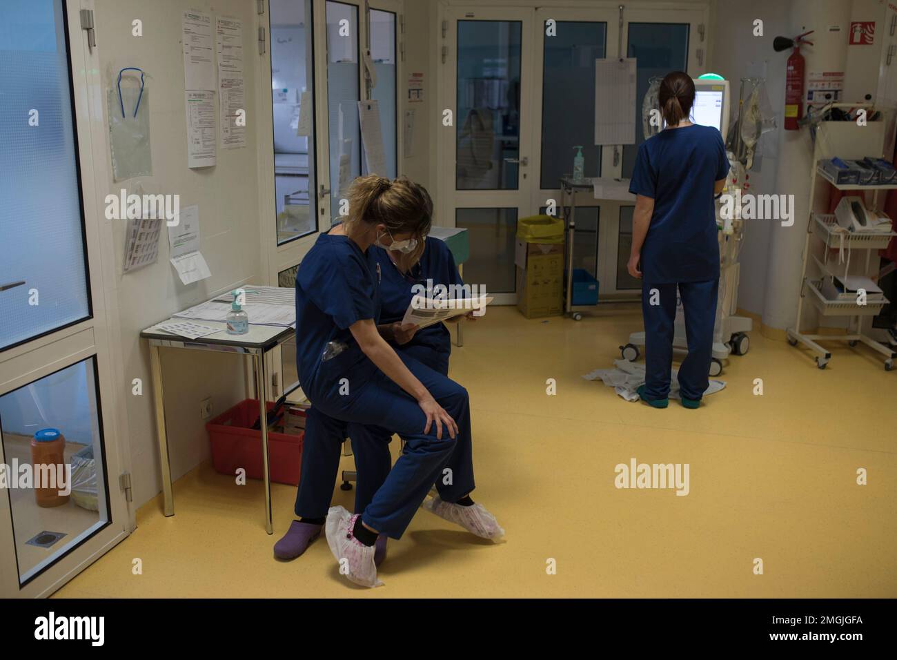 Healthcare workers sit together to review the medical information of a ...