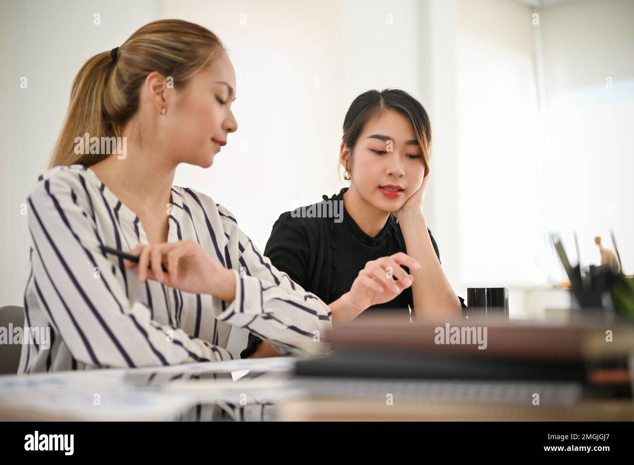 Two professional and smart millennial Asian businesswomen or female ...