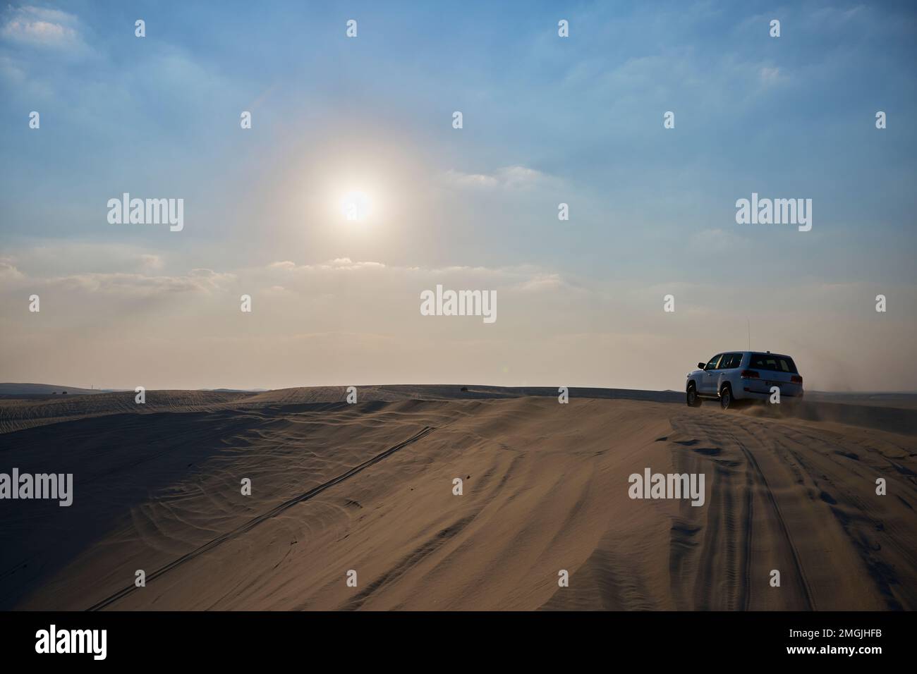 Watching people riding in 4x4's racing over the dunes near Doha, where ...