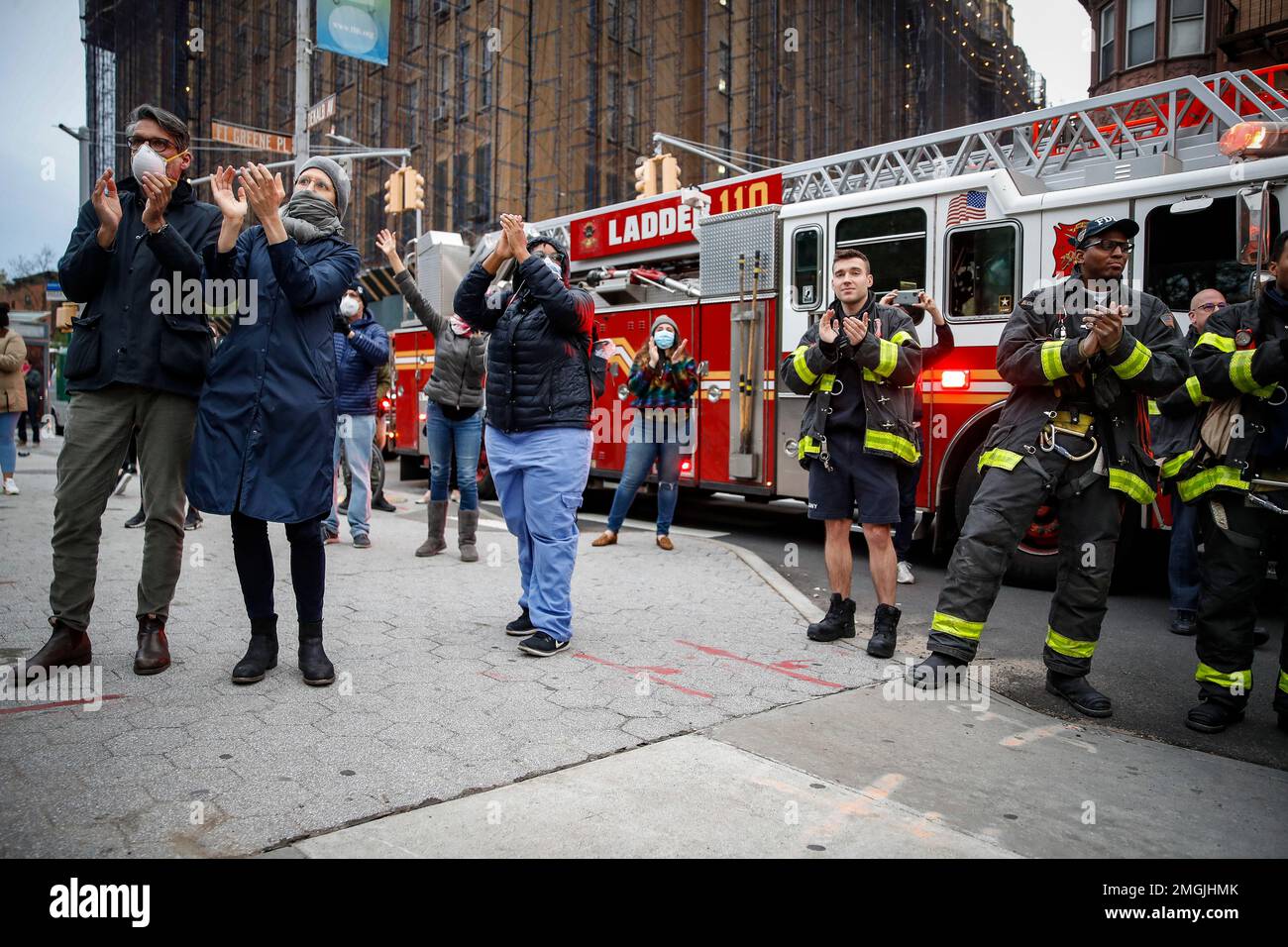 Pedestrians and FDNY firefighters gather to applaud medical workers at ...