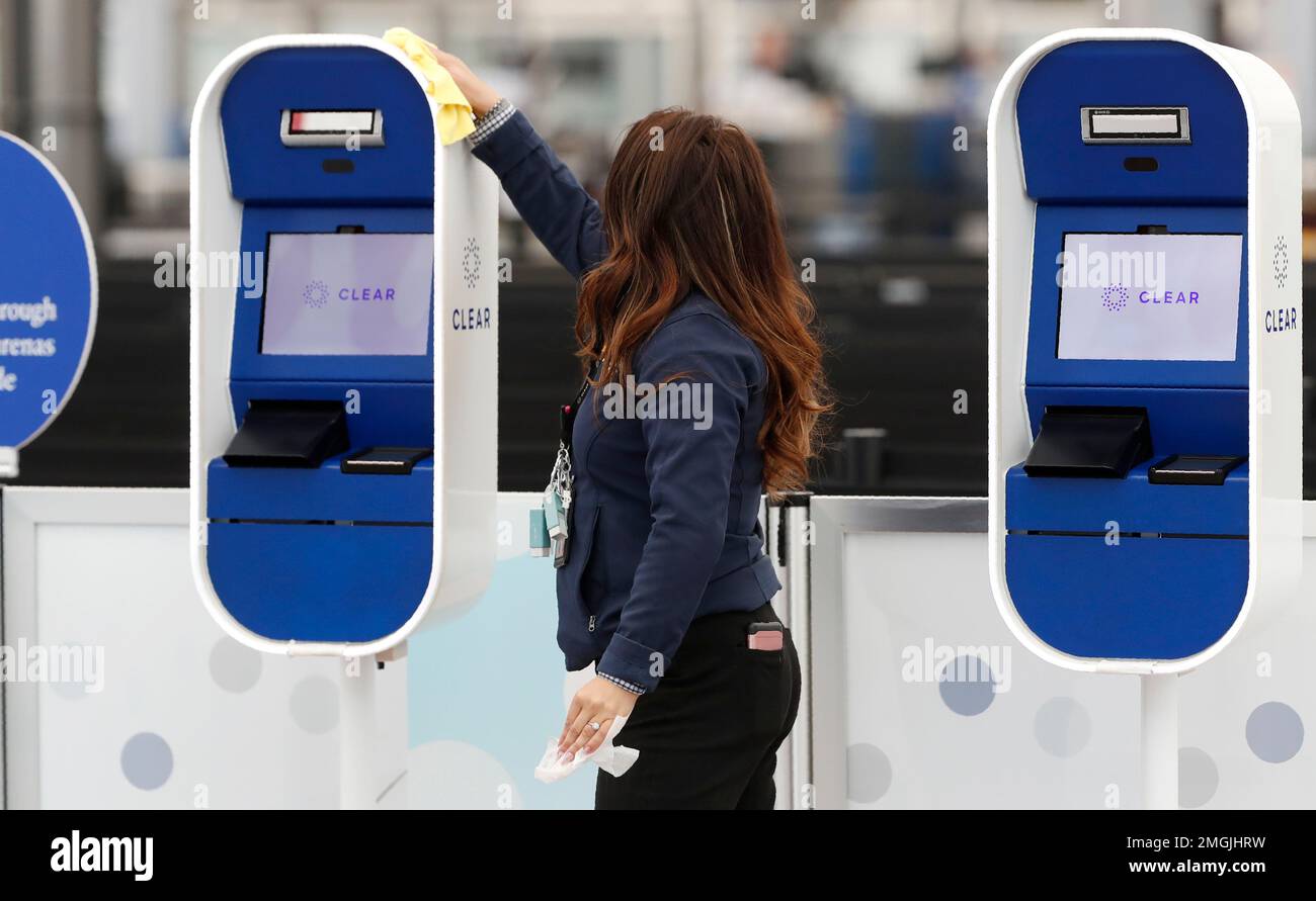 A representative from Clear cleans the machines at Denver International ...