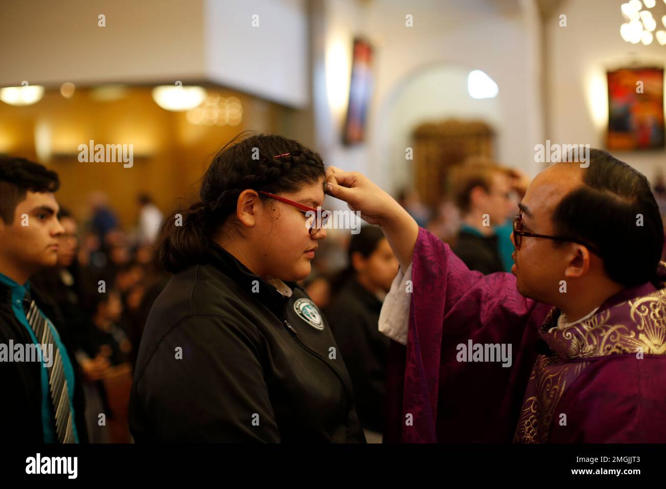 A priest marks repentance ashes on the foreheads of students from the ...