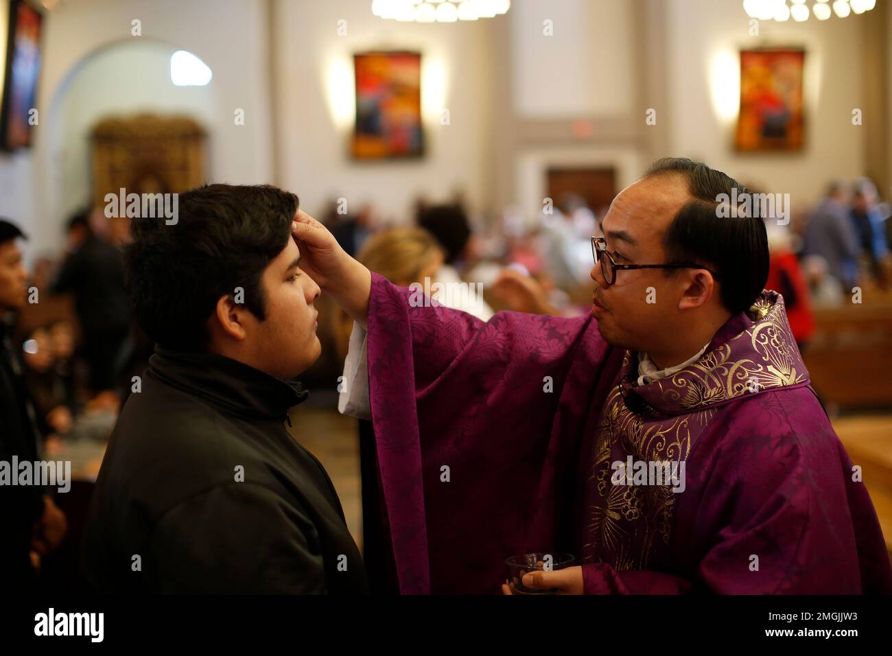 A priest marks repentance ashes on the foreheads of students from the ...
