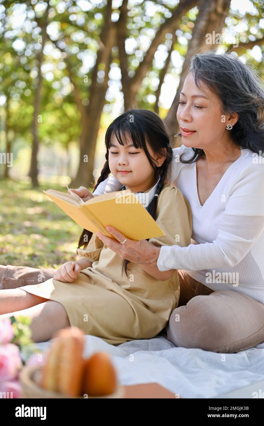 Portrait, Happy Asian grandmother telling story, reading fairly tales ...